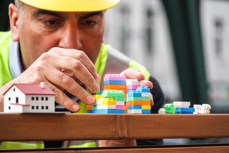 Construction Worker Using Colourful Toy Bricks Stock Photo - Image of ...