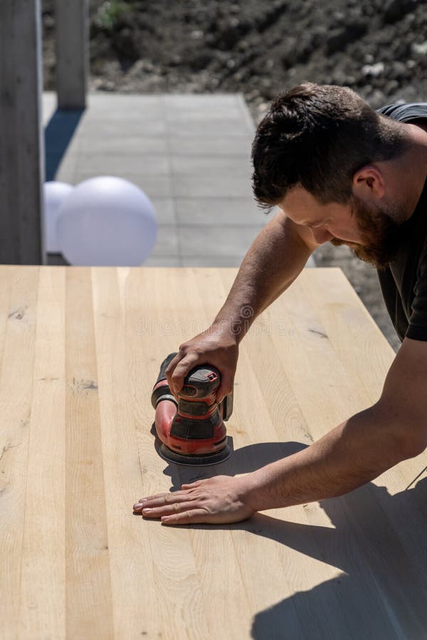 Construction Worker Using a Cordless Power Sander To Sand a Massive ...
