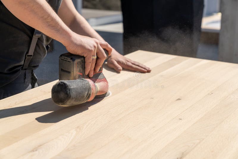 Construction Worker Using a Cordless Power Sander To Sand a Massive ...
