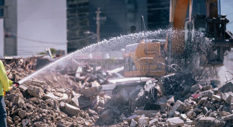 Construction Worker is Using a High-pressure Water Hose To Power Wash ...