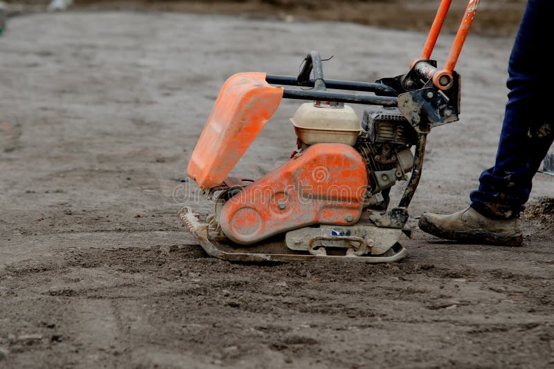 Construction Worker Using Petrol Powered Plate Compactor To Compact ...