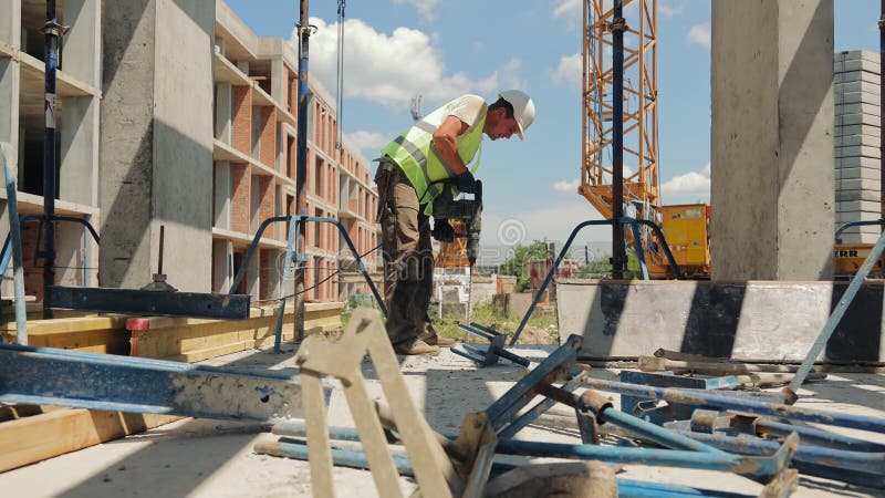 Construction Worker Using Power Tool on Site. a Construction Worker ...