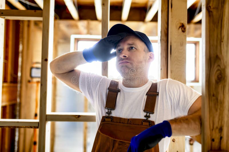 Construction Worker Using Power Tool in Unfinished Basement of New Home ...