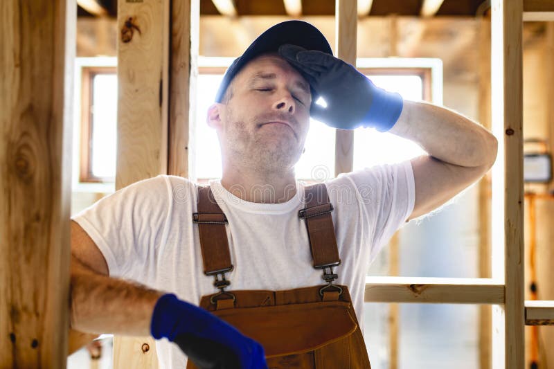 Construction Worker Using Power Tool in Unfinished Basement of New Home ...