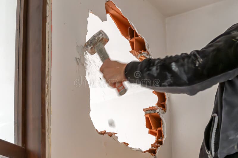Construction Worker Demolishing Interior Brick Wall with Sledgehammer ...