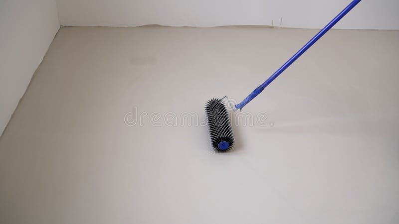 Construction Worker Using a Spiked Roller To Level the Floor. Stock ...