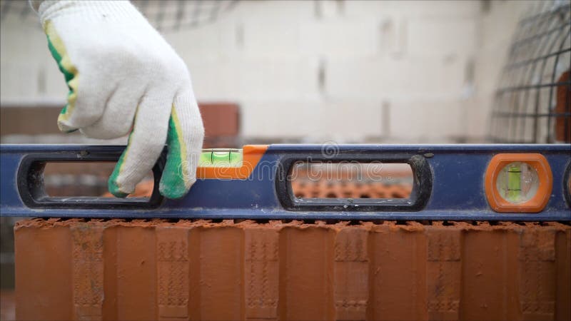 Construction Worker Using Spirit Level on Brick Wall Ensuring Precise ...