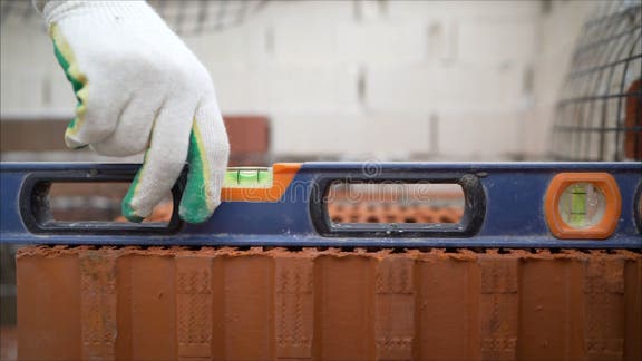 Construction Worker Using Spirit Level on Brick Wall Ensuring Precise ...