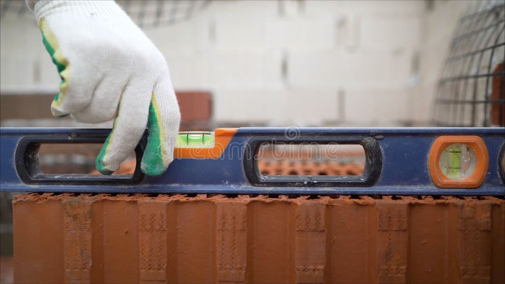 Construction Worker Using Spirit Level on Brick Wall Ensuring Precise ...