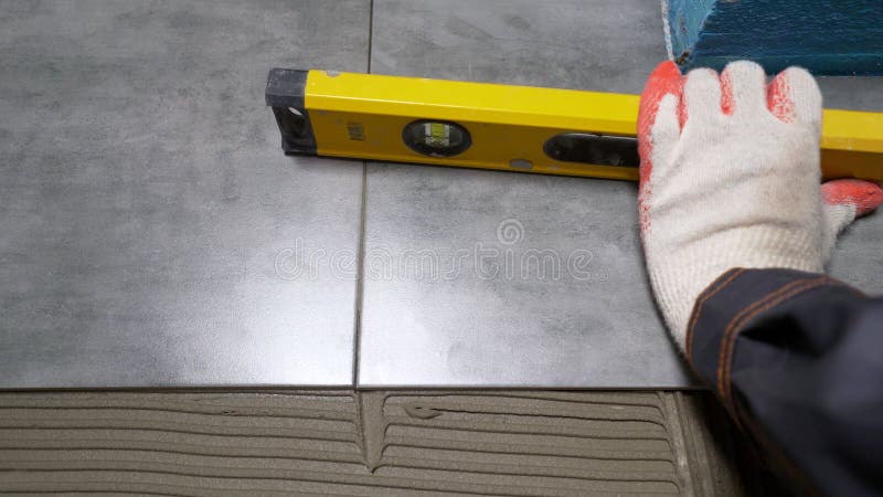 Construction Worker Leveling Floor Tiles Using Spirit Level. Stock ...