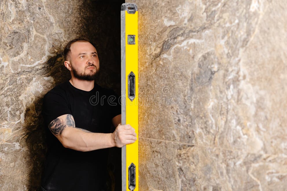 Construction Worker Using Spirit Level Installing Marble Tile on Wall ...