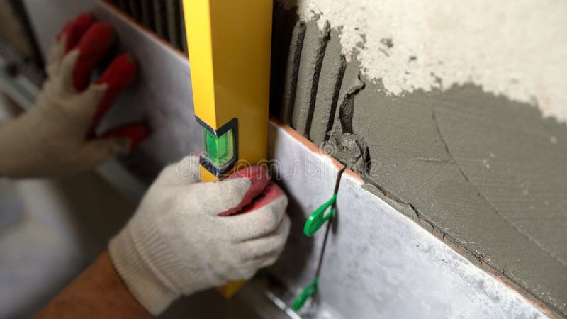 Construction Worker Leveling Tiles on Wall with Leveling Tool Stock ...