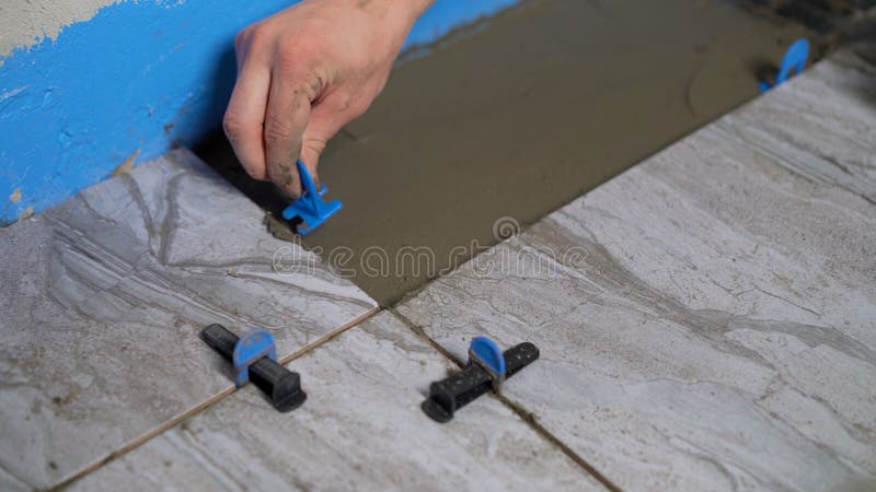 Construction Worker Placing Tile Leveling System while Laying Floor ...