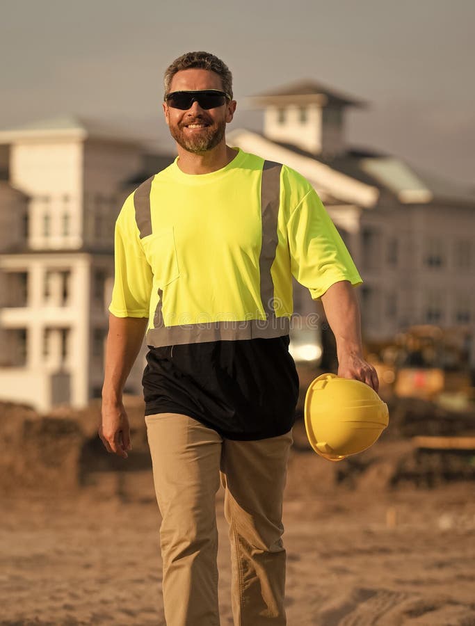 Construction Worker Walking at Construction Site. Smiling Man Holding ...