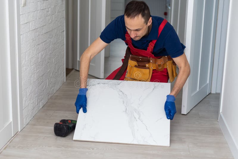 Construction Worker Wearing Bib Overalls and Hard Hat Cutting Ceramic ...