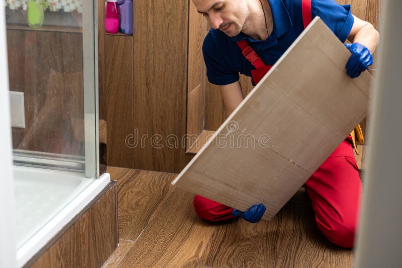 Construction Worker Wearing Bib Overalls and Hard Hat Cutting Ceramic ...