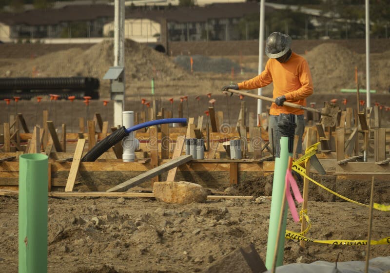 A Construction Worker Wearing a Helmet and Full Face Covering Digging a ...