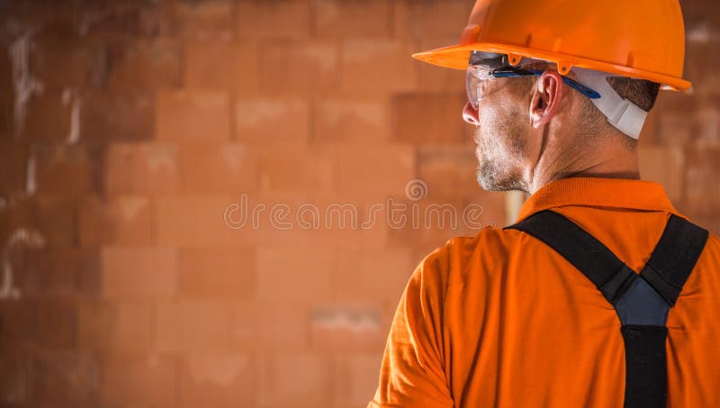 Construction Worker Wearing Safety Gear and Orange Uniform Assesses ...