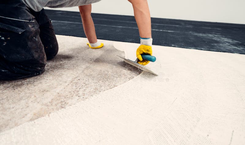 Construction Worker Spreading Self-leveling Concrete on the Floor Using ...