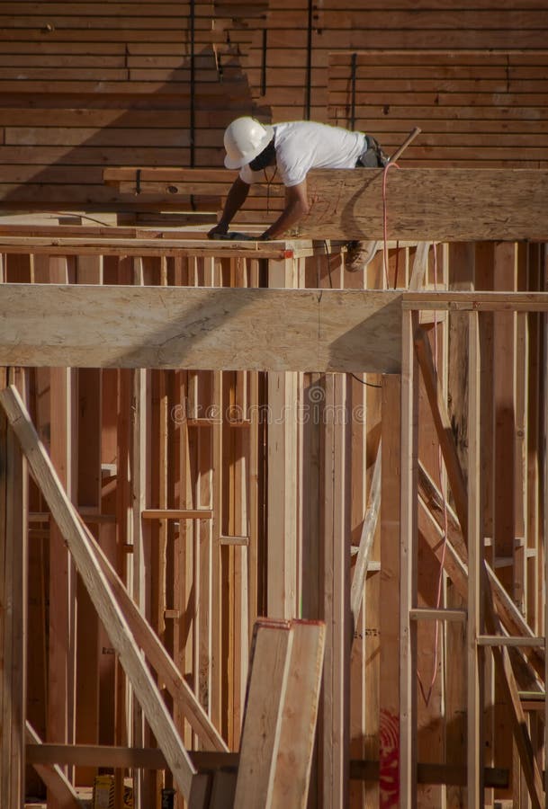 Vertical Image of a Construction Worker on Wood Framing with White Hard ...