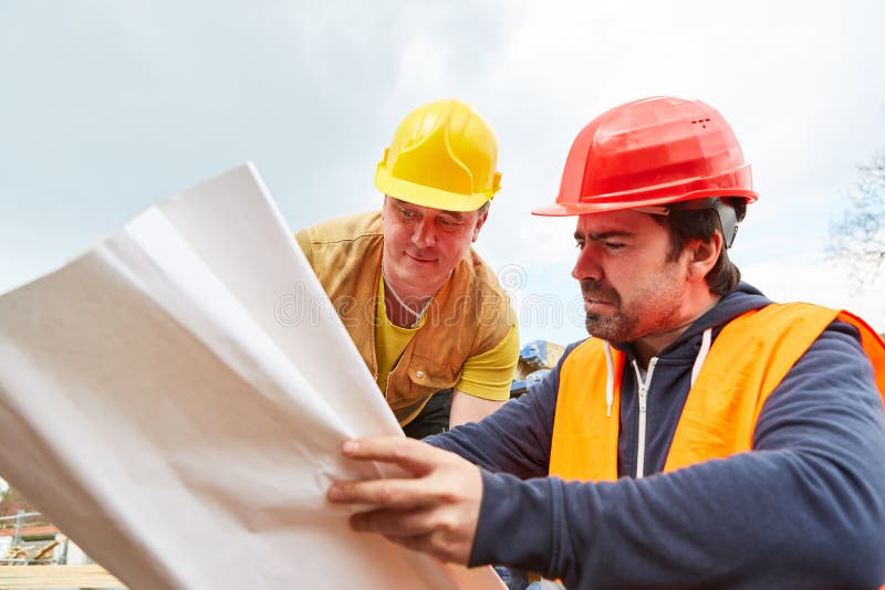 Construction Workers and Architect Look at Construction Drawing Stock ...
