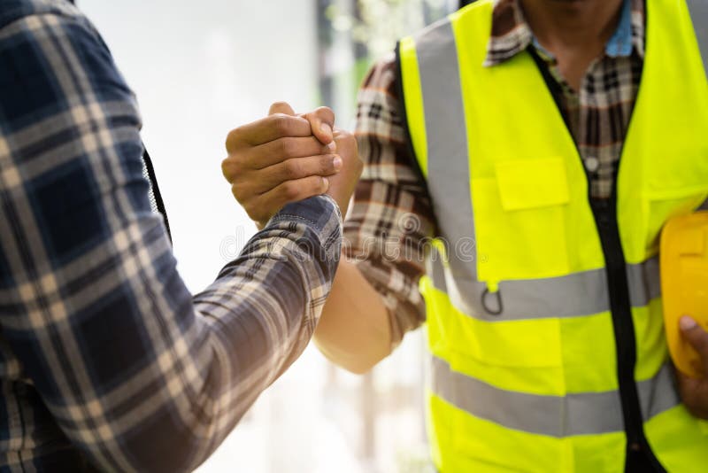 Construction Workers, Architects and Engineers Shake Hands while ...
