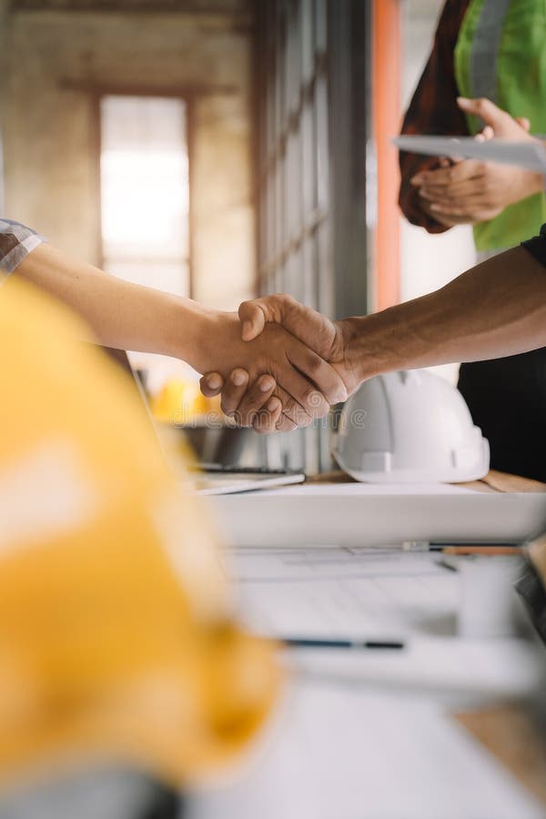 Construction Workers, Architects and Engineers Shake Hands while ...