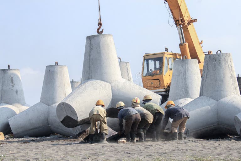 Construction Workers Assembling Concrete Tetrapods for Wave Breaker ...