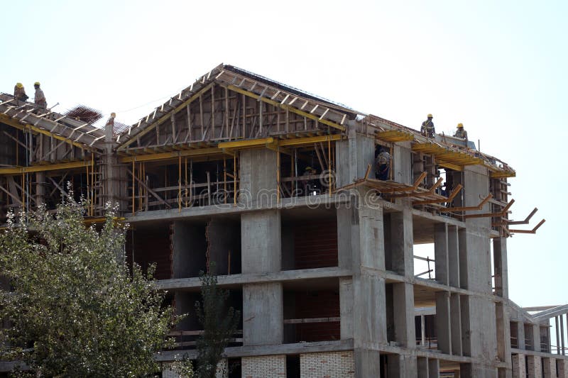 Construction Workers Build a Multi-story Residential Building in a ...