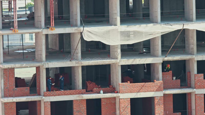 Construction Workers Building Brick Wall on a Building Site Stock ...
