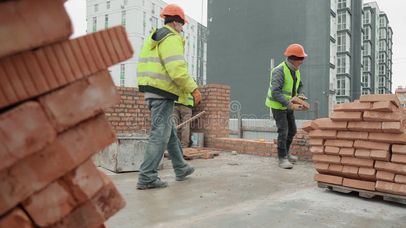 Construction Workers Building Brick Wall Outdoors. Three Construction ...