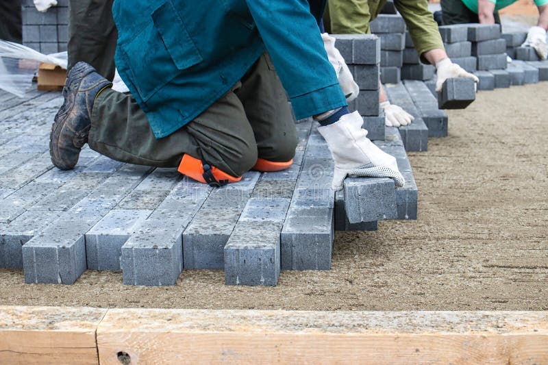 Workers Laying Gray Paving Stones in a Construction Project at a Public ...