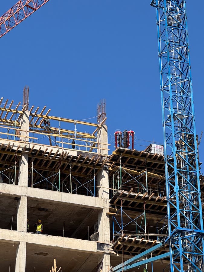 Construction Workers Collaborating on Building Site with Crane and ...