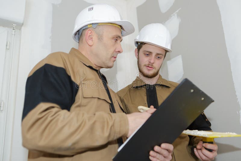 Construction Workers Consulting Plans in New Home Stock Photo - Image ...