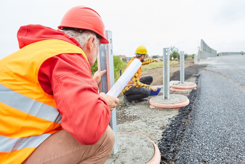 Construction Workers at Control of the Crash Barriers Construction ...