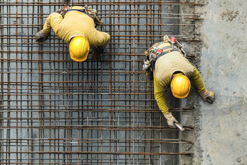 Construction Workers Creating a Robust Steel Mesh Concrete Wall Under ...