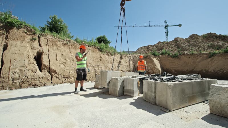 Construction Workers Direct Heavy Concrete Blocks with Crane on ...