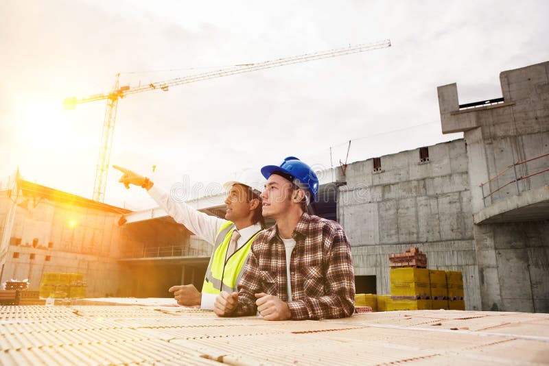 Construction Workers Discussing Job at Building Site Stock Photo ...