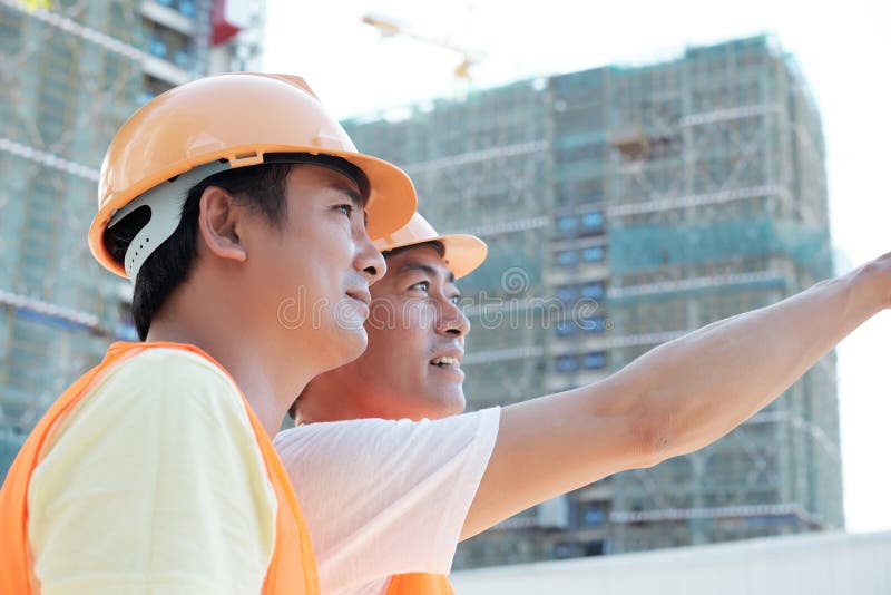 Construction Workers Discussing Work Stock Image - Image of vest ...