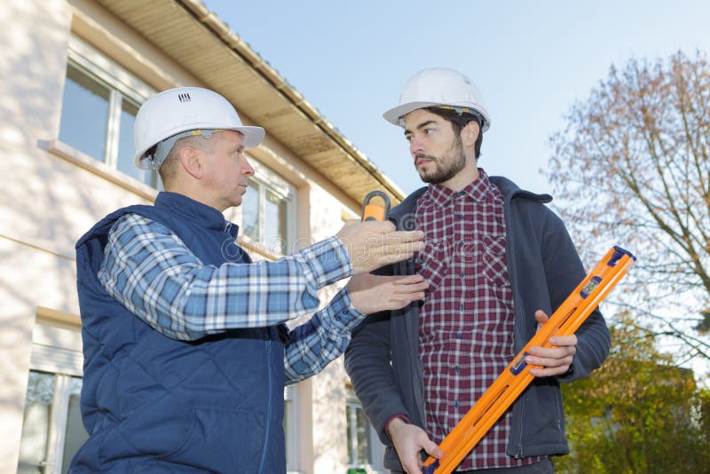 Construction Workers in Discussion in Yard Stock Image - Image of home ...