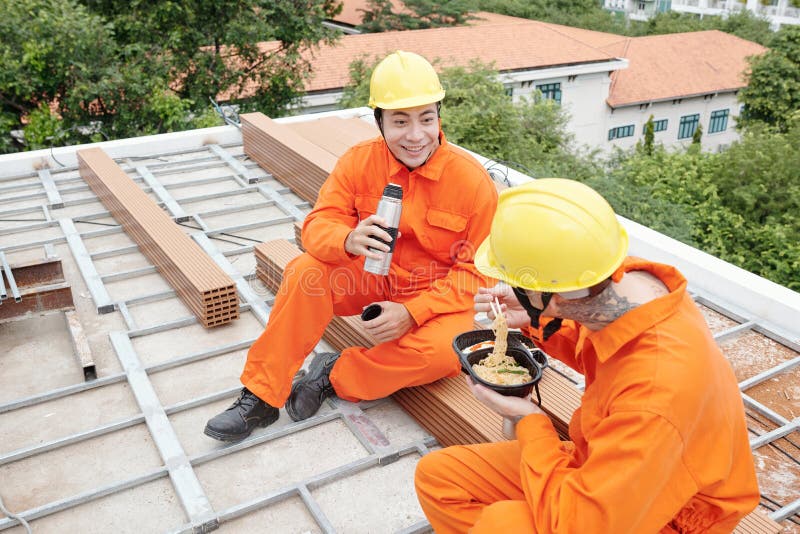 Construction Workers Eating on Rooftop Stock Image - Image of helmet ...