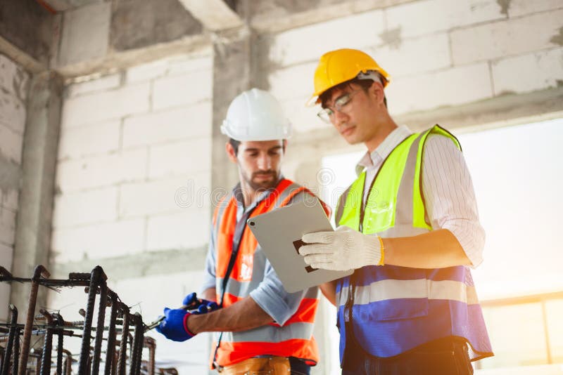 Construction Workers and Engineers Discuss Work on a Construction Site ...