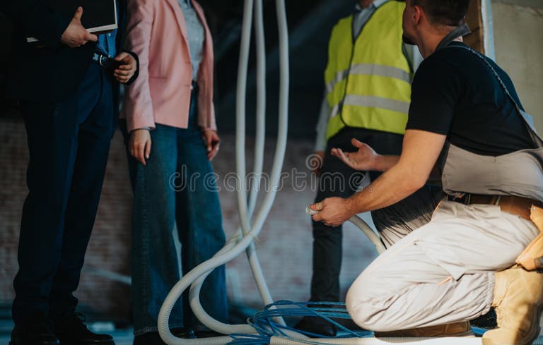 Construction Workers and Engineers Discussing Site Plans Inside a ...