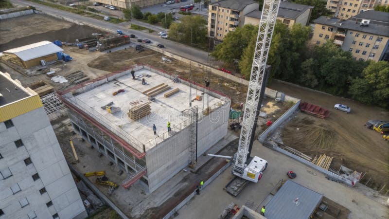 Construction Workers Erecting Concrete Structure Using Crane, Revealing Urban Development ...
