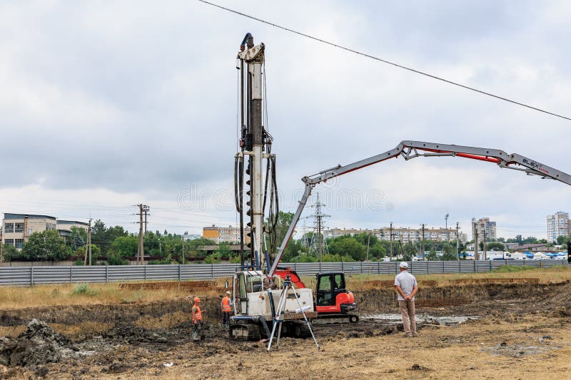 Construction Workers with Heavy Machinery Drilling in Open Field. June ...