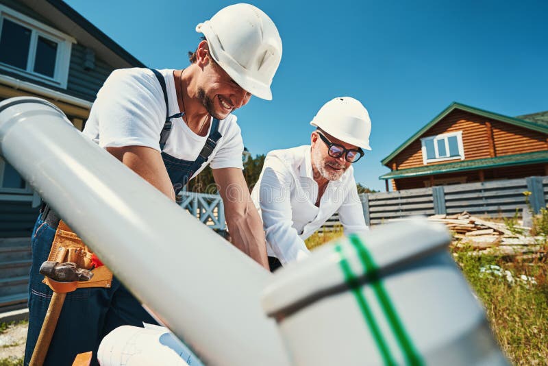 Construction Workers in Helmets Leaning Over Table Stock Image - Image ...