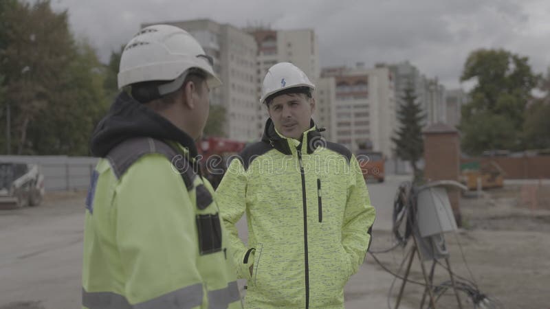 Construction Workers in Jackets and Helmets Stand on Site Stock Video ...