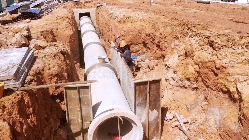 Construction Workers Install Concrete Pipe Culvert in the Underground ...