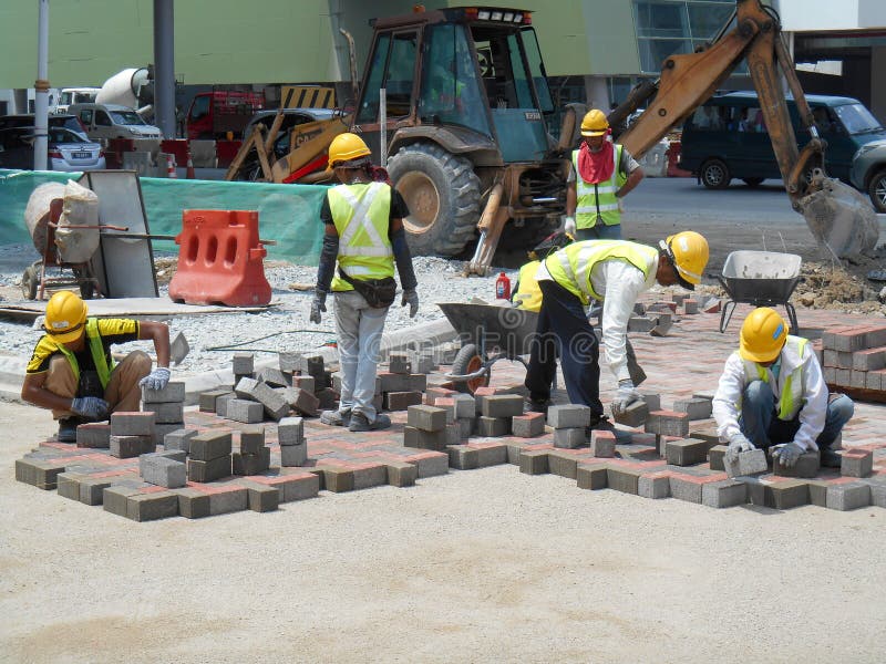 Construction Workers Installing and Arranging Precast Concrete Pavers ...