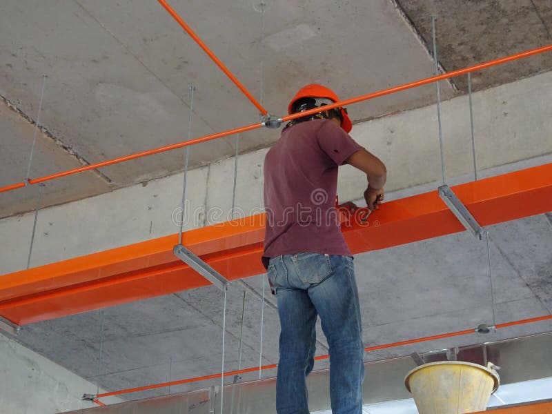 Construction Workers Installing Electrical Cable Tray and Doing Wiring ...